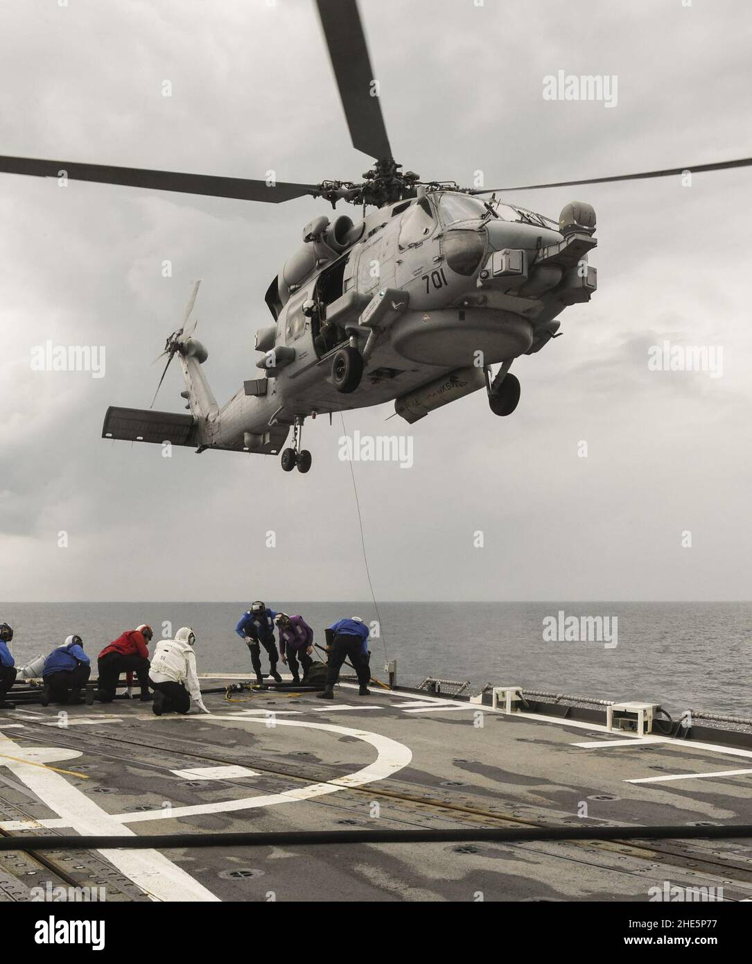 Sailors on the flight deck of USS Antietam (CG-54) send up fuel samples ...