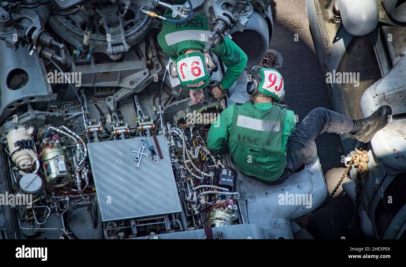 Sailors perform maintenance on an MH-60S Sea Hawk helicopter ...