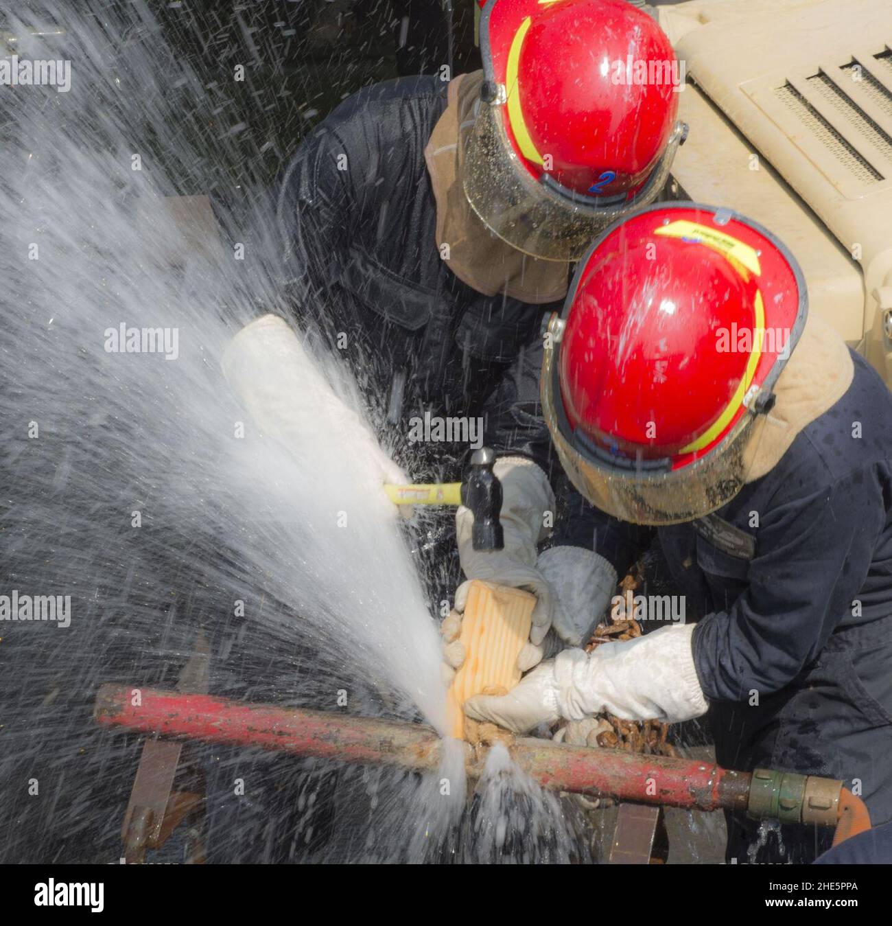 Sailors practice fixing a broken pipe during a damage control training ...