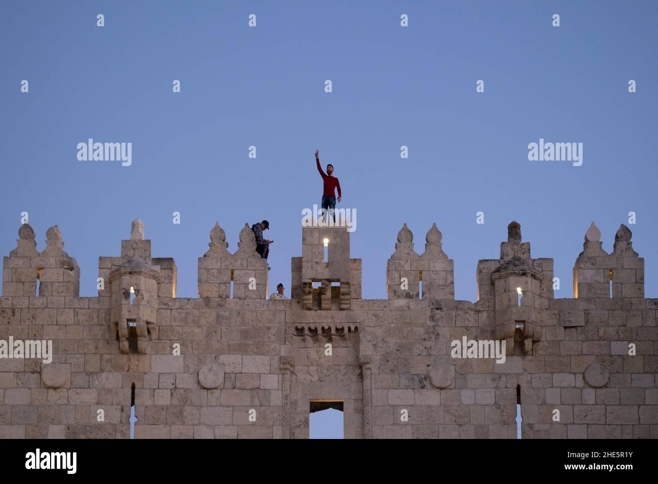 Young Palestinian marks the victory sign as he stands over the ...