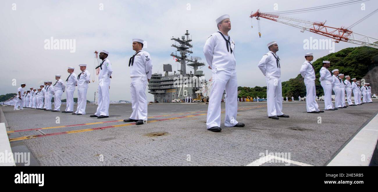 Sailors stand at parade rest on the flight deck of USS Ronald Reagan ...