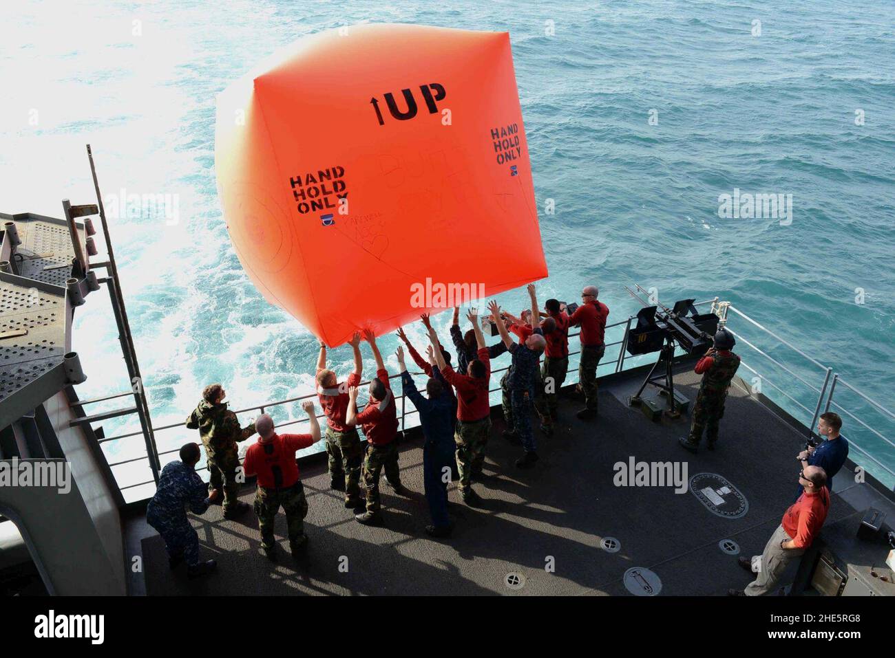 Sailors toss a floating target overboard. (8357468191 Stock Photo - Alamy