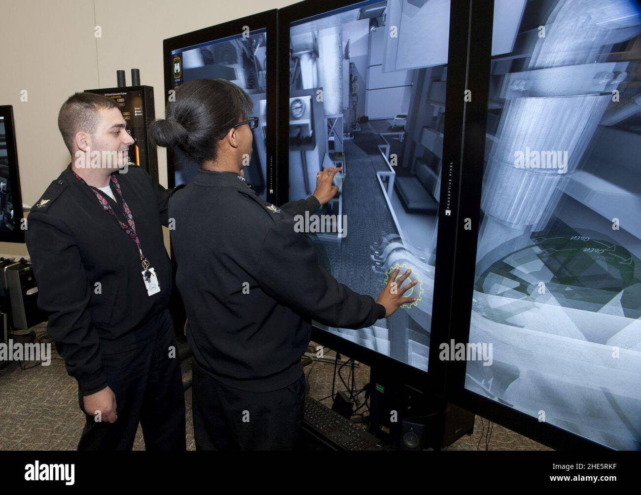 Sailors use a Submarine Engine Room touch-screen training simulator ...
