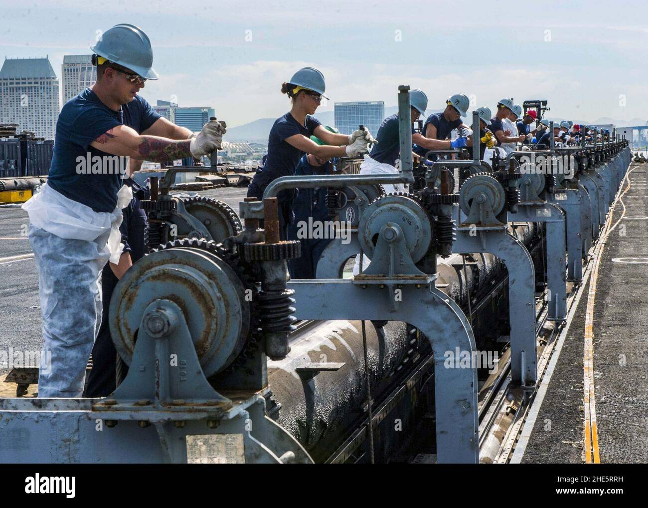Sailors work together to lower a catapult track back into the flight ...
