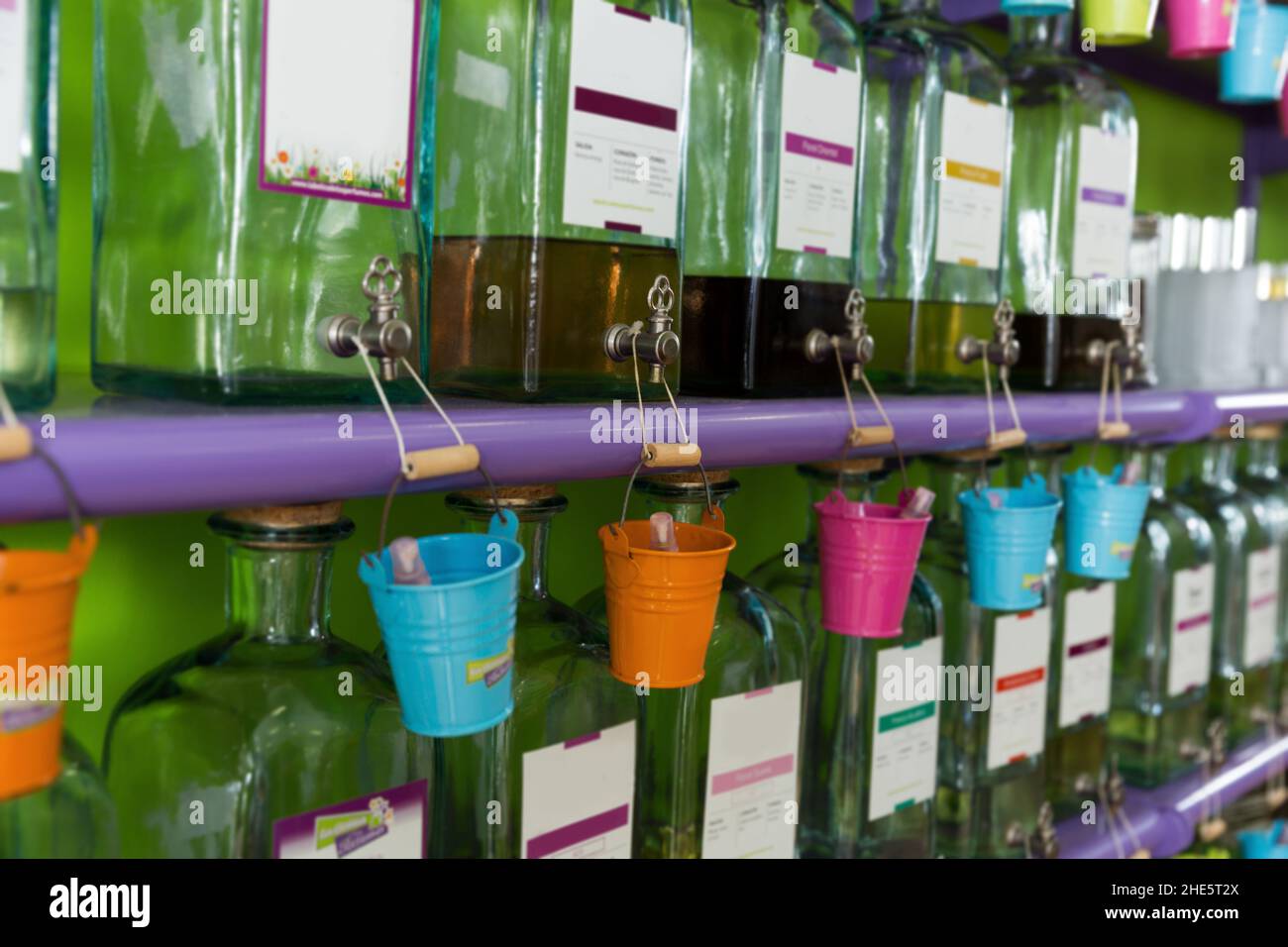 Colored pails hanging on taps of perfume bottles on shelves Stock Photo ...
