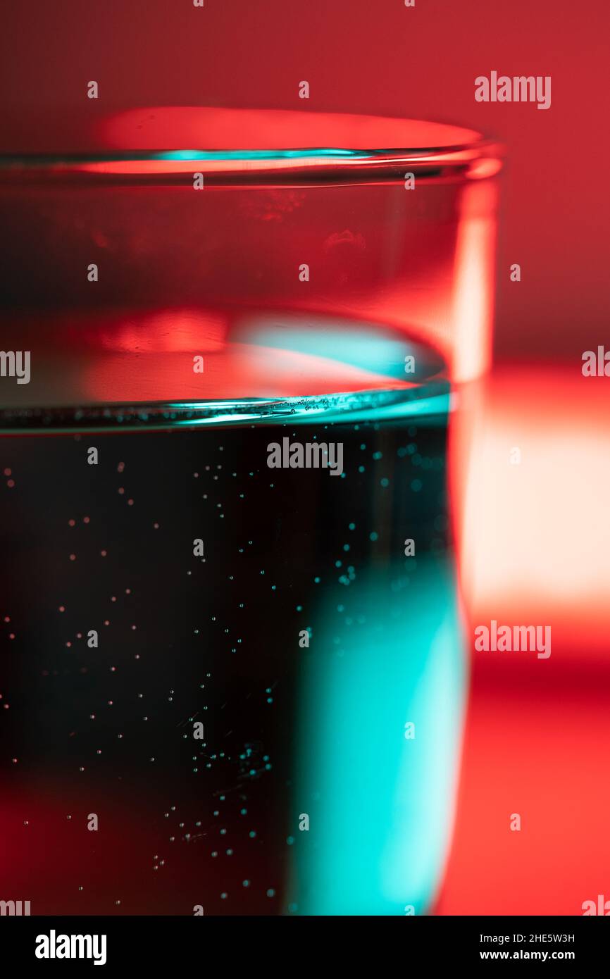 Macro shot of glass of water in red blue trendy neon light Stock Photo ...