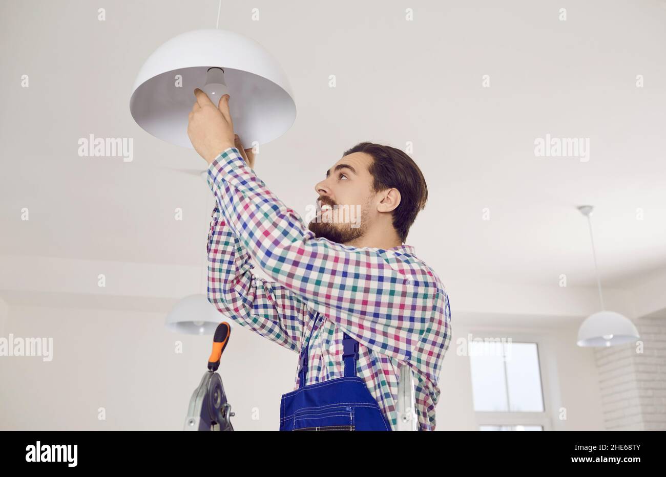 Man changing light bulb on ladder hi-res stock photography and images ...