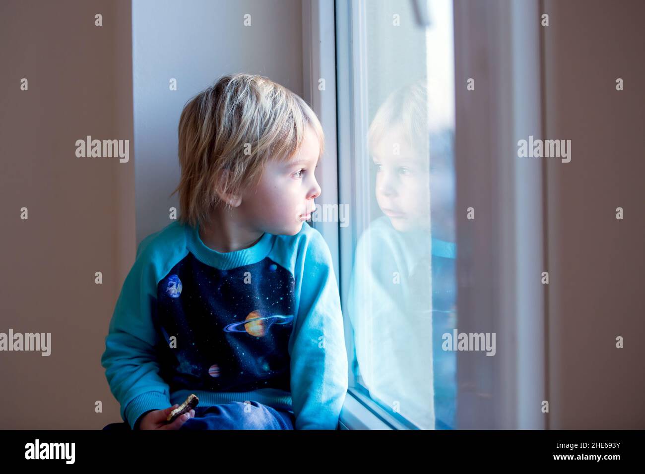 toddler child, sitting on the window on sunset, looking out Stock Photo ...
