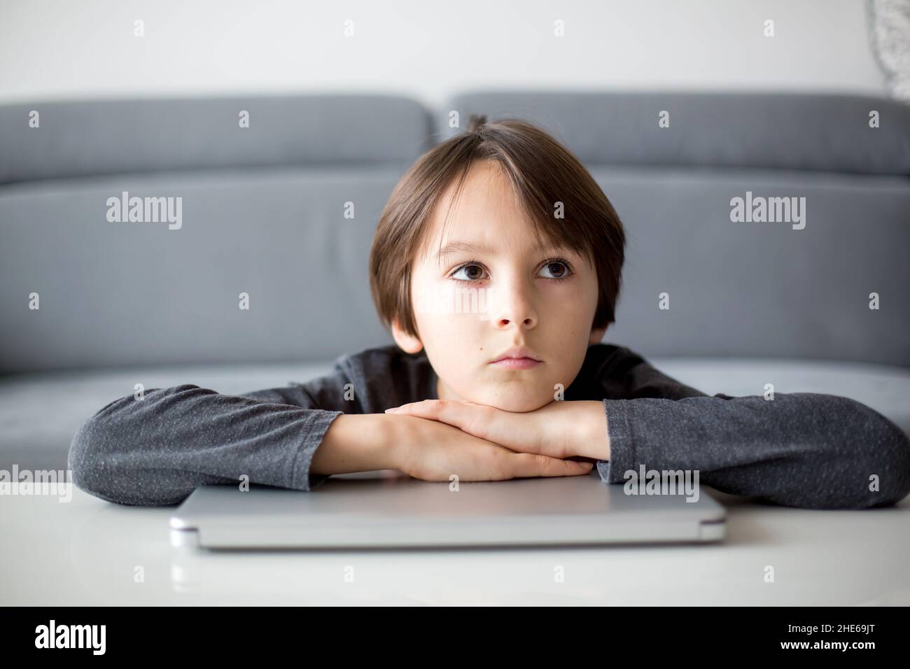 Preteen child, hiding behind notebook, online education, games and fun ...