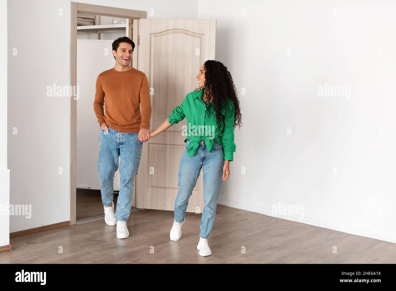 Happy woman inviting guy to enter home Stock Photo - Alamy