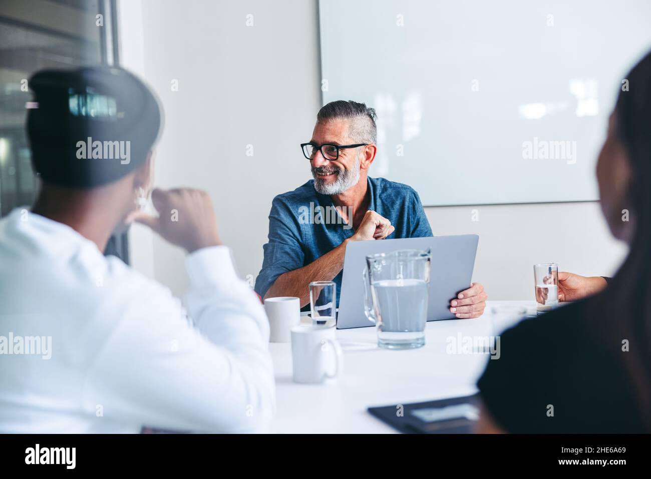 Mature supervisor having a meeting with his colleagues in an office ...
