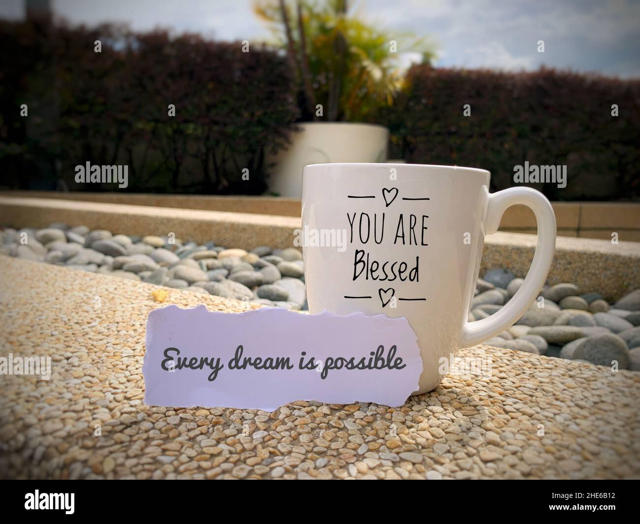 Every dream is possible text on rip paper with coffee mug and park ...