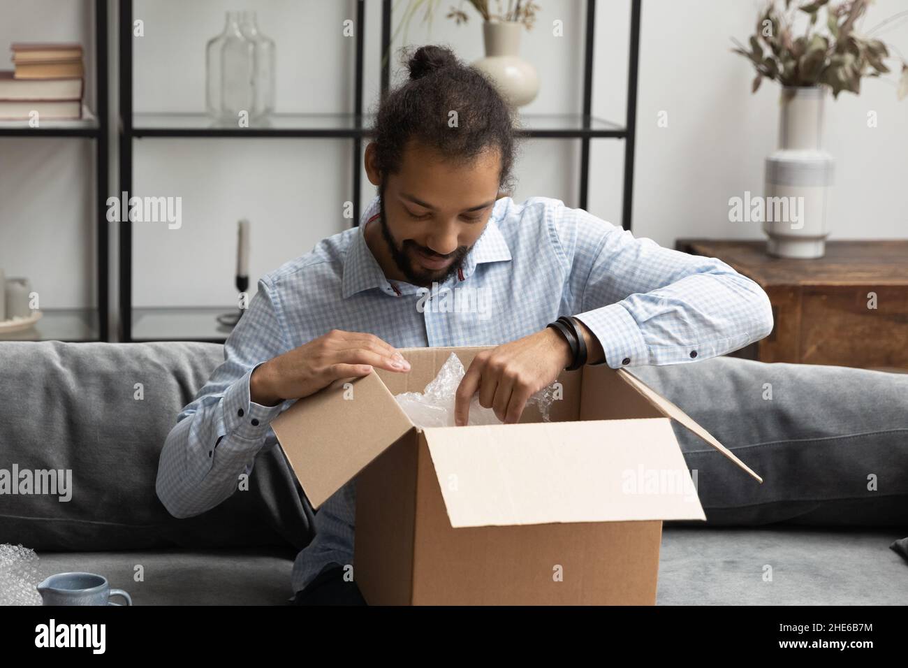 Happy focused engaged Black customer receiving purchase from internet ...