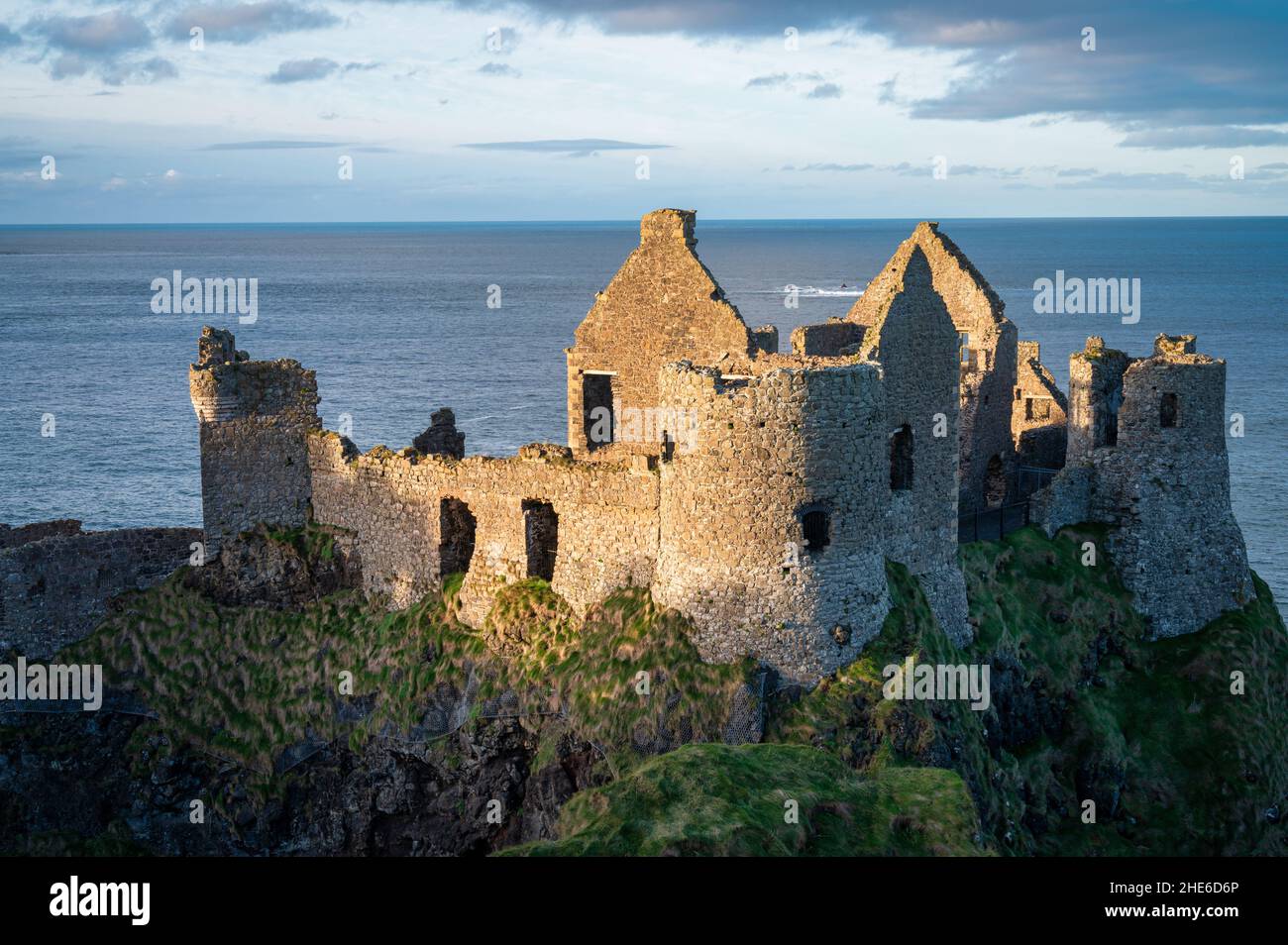 The ruins of Dunluce Castle on the edge of s sea cliff on the coast of ...