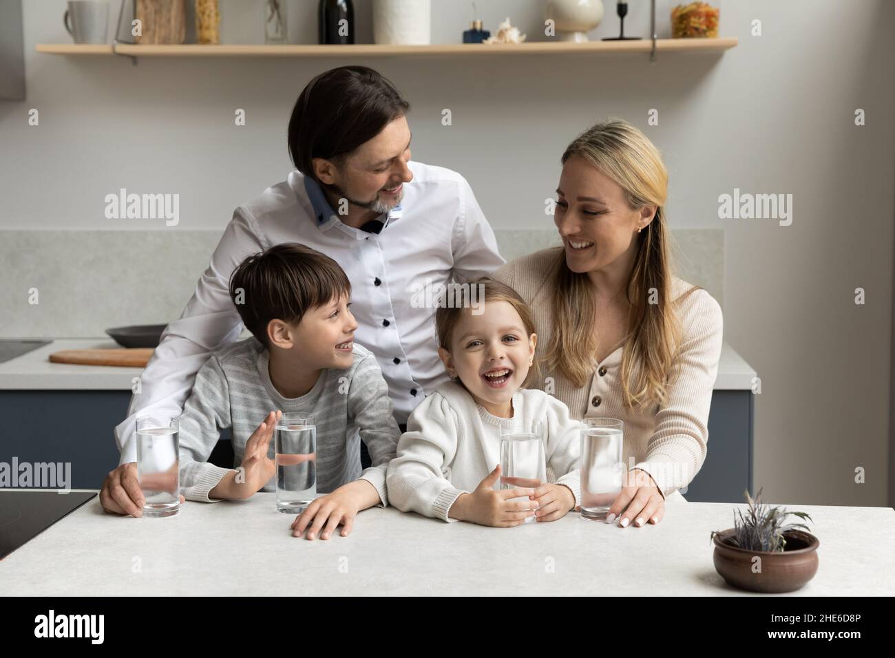 Happy parents and two healthy sibling kids drinking water Stock Photo ...