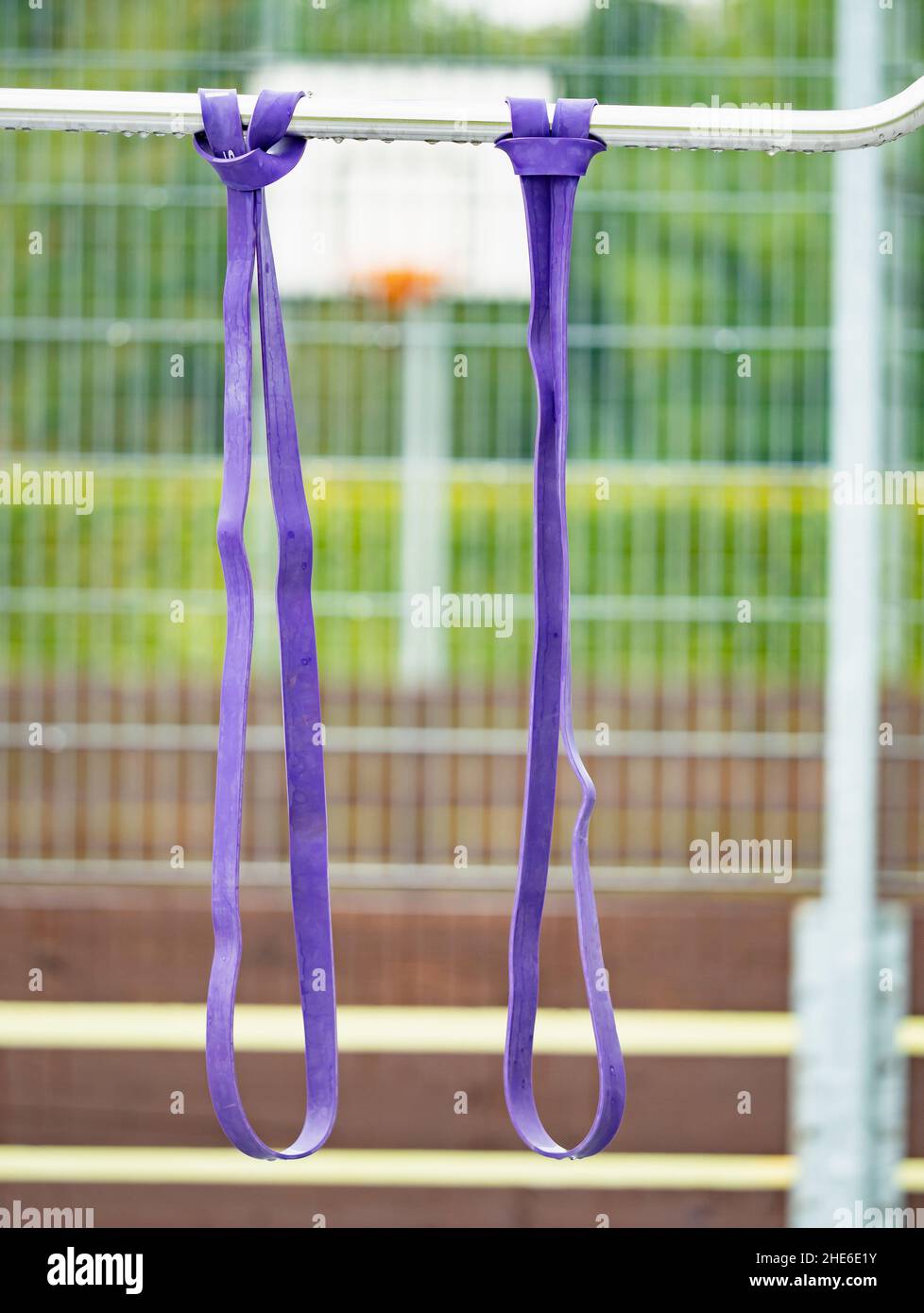 Purple bands from latex hand on chrome bar on fitness playground. Funy ...