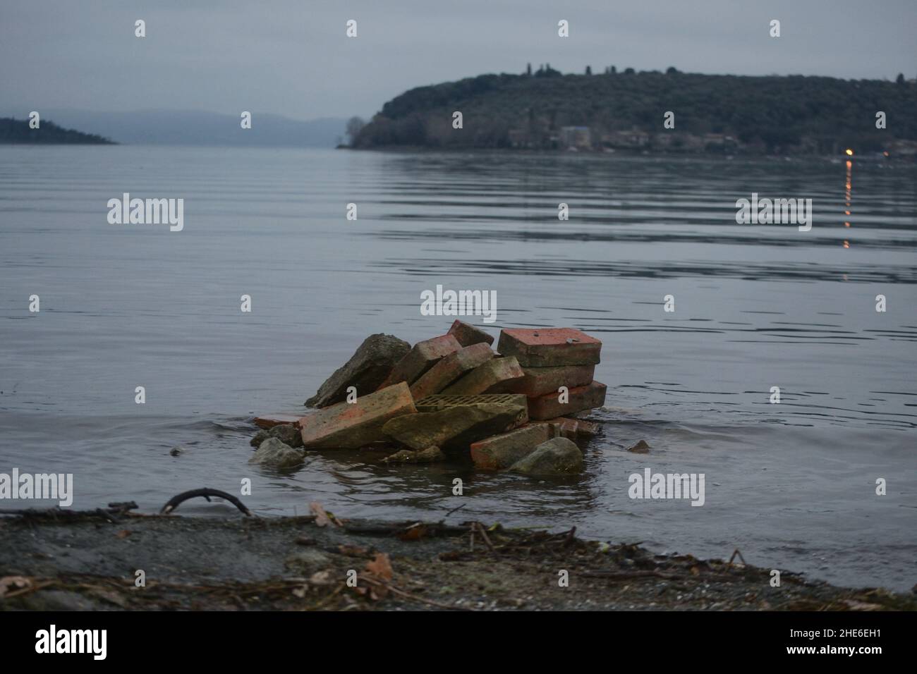 group of bricks on the lakeshore with isola maggiore on the background ...
