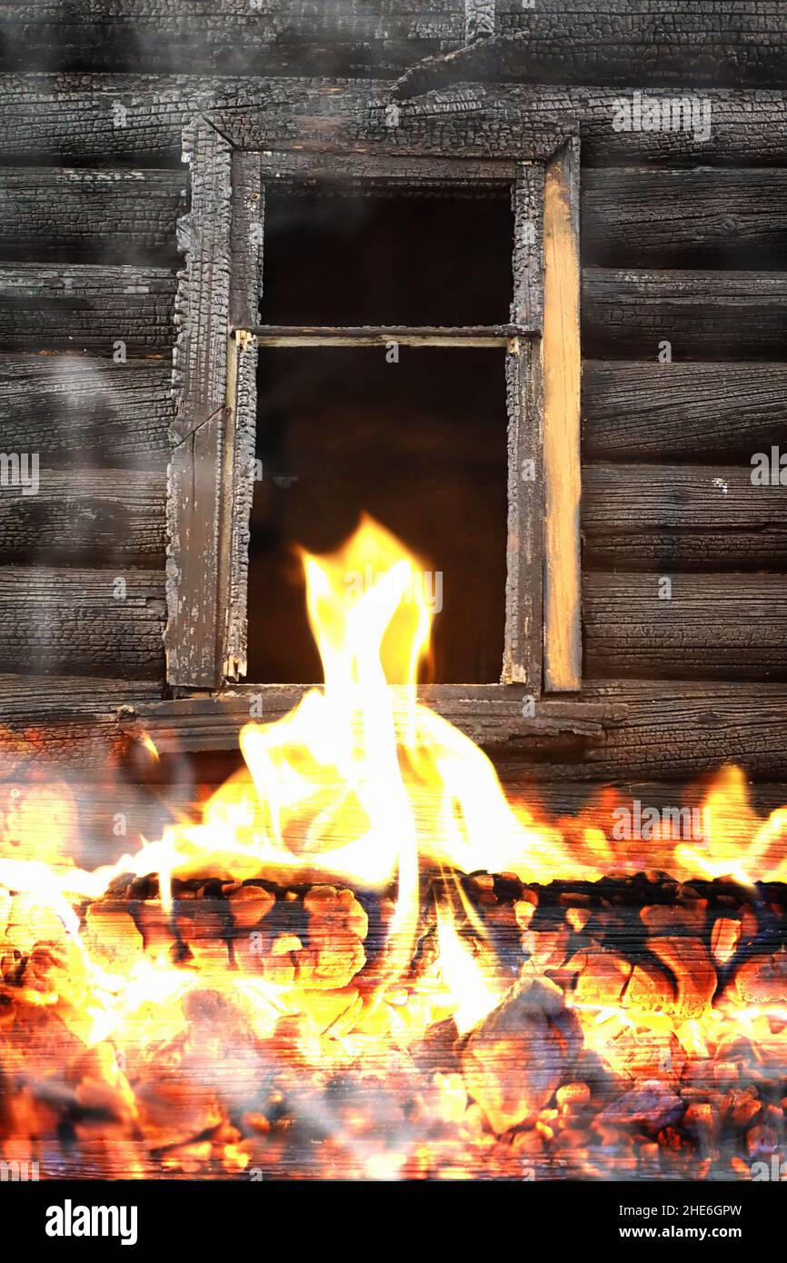 Wooden house after the fire. Coals on the logs. The ashes of the house ...