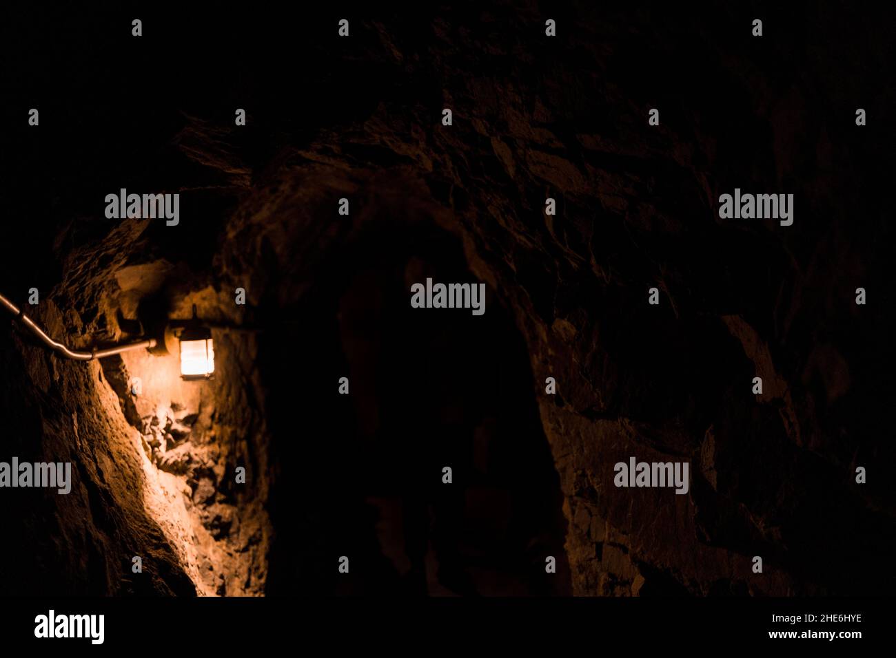 Old glowing lamp inside a dark stone cave Stock Photo - Alamy