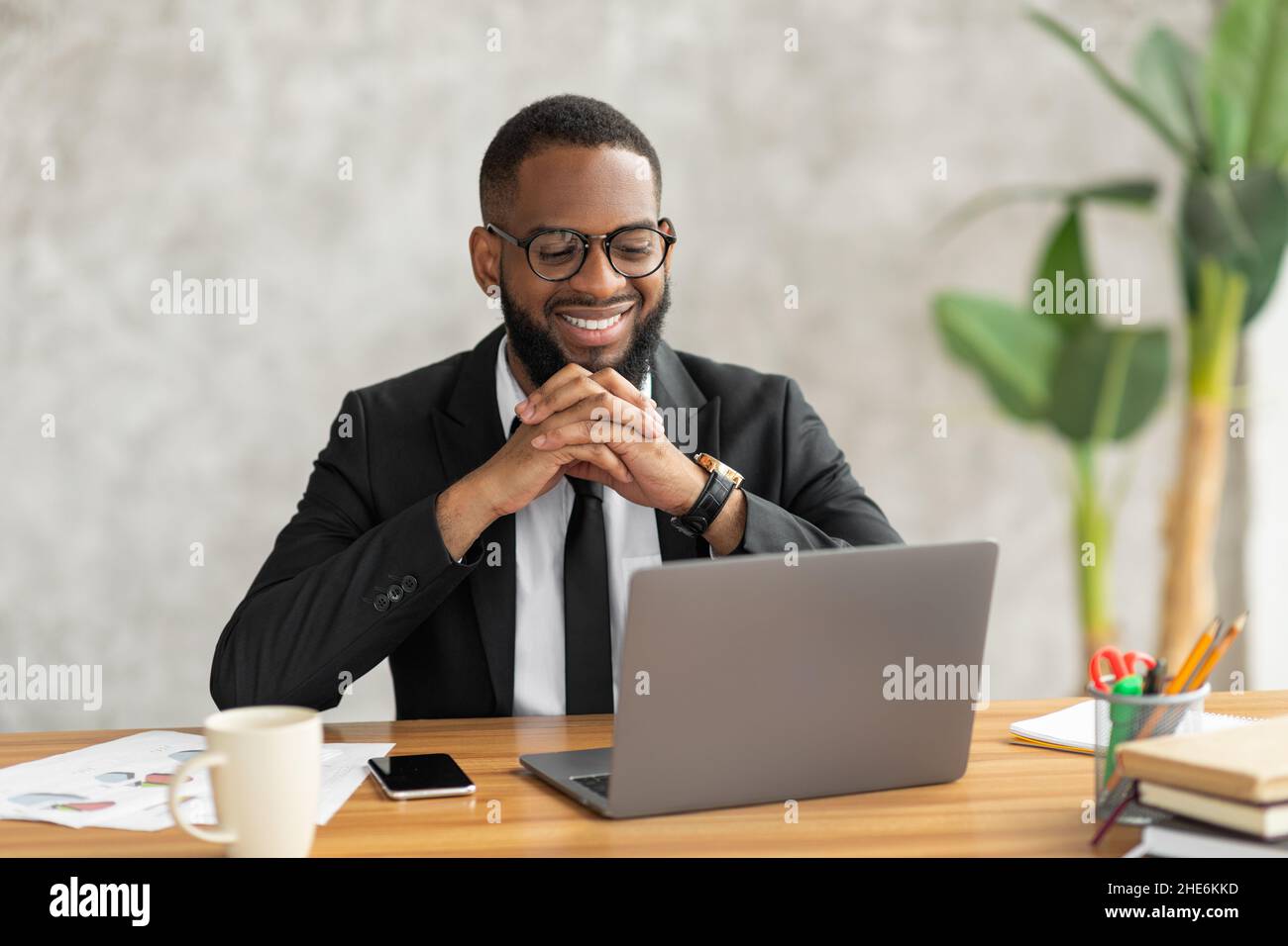 Smiling black man watching video on computer Stock Photo - Alamy