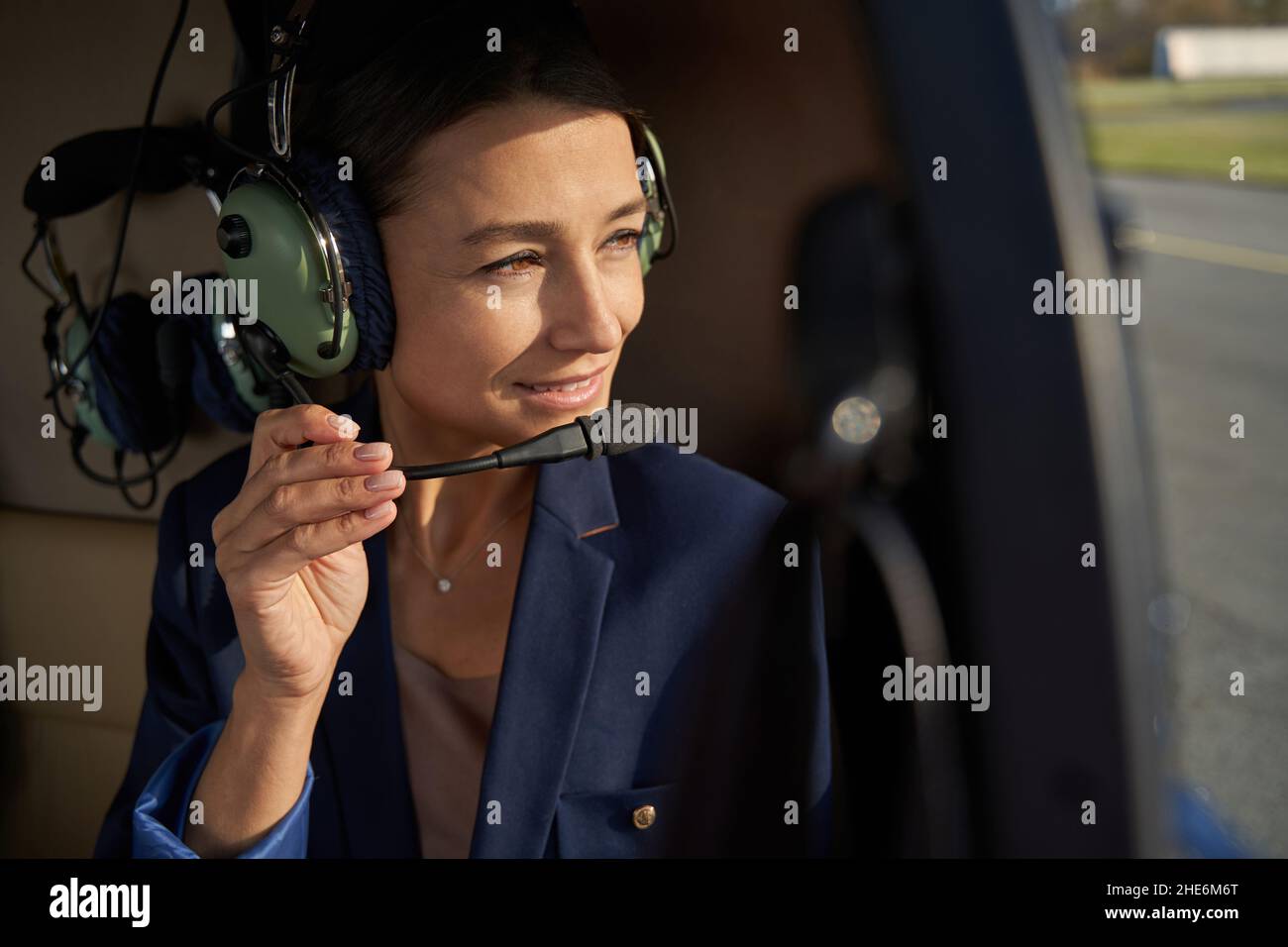 Pleased female passenger speaking into microphone mid-flight Stock ...