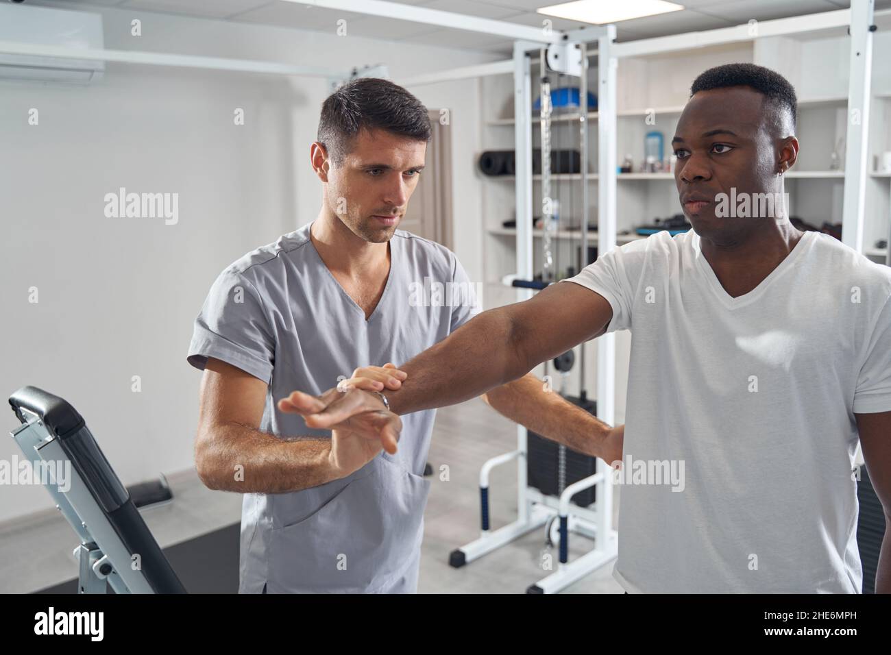 Focused physiotherapist carrying out resisted isometric test Stock ...