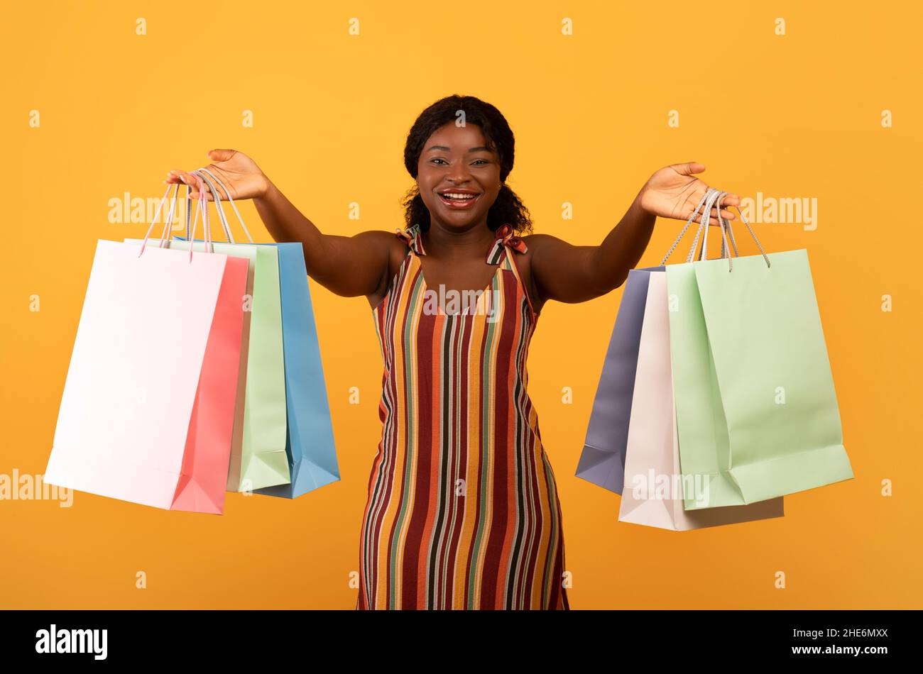 Seasonal sales and shopping. Charming young black woman showing bright ...