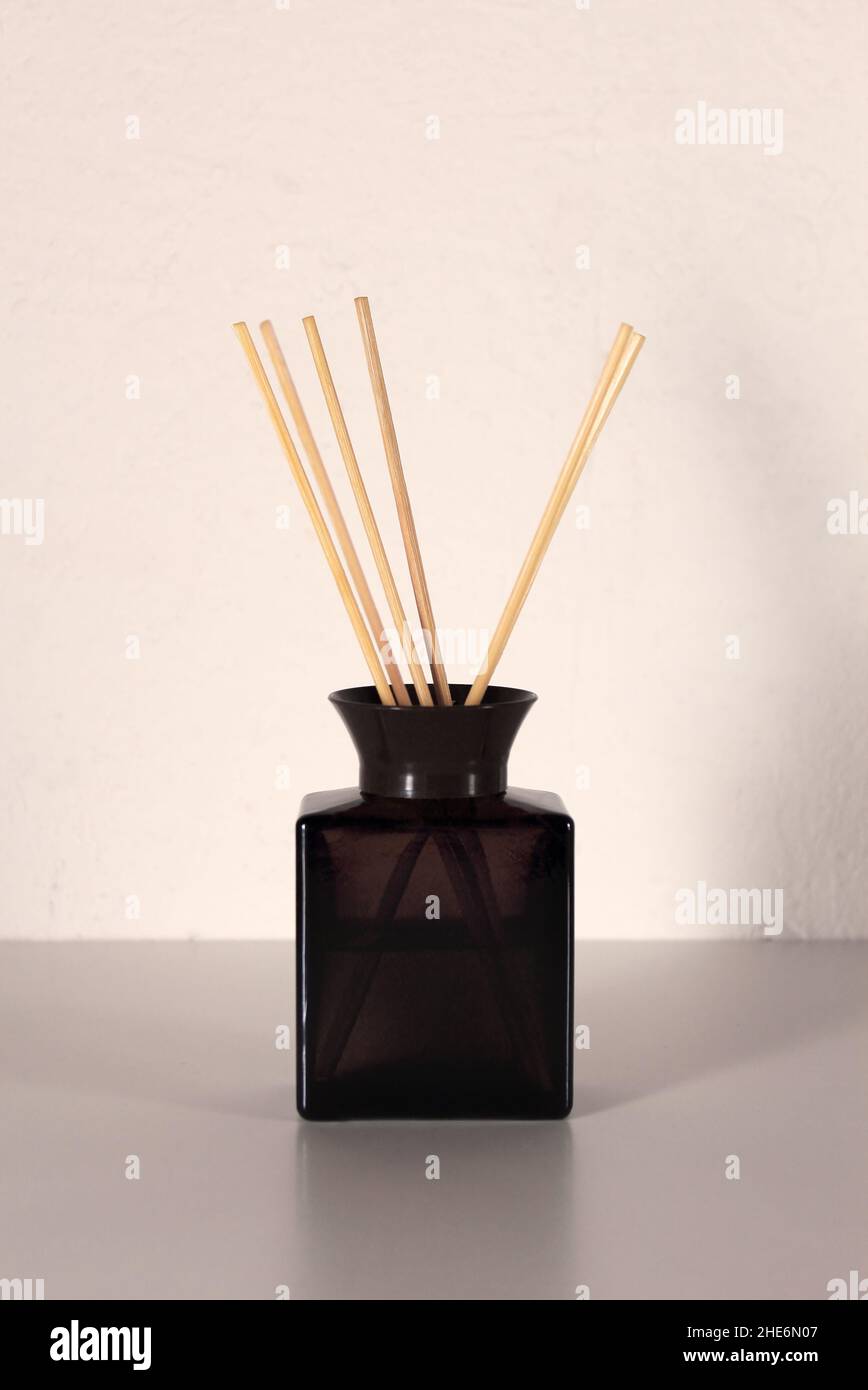 Aroma diffuser with wooden sticks for home on background of white paint ...