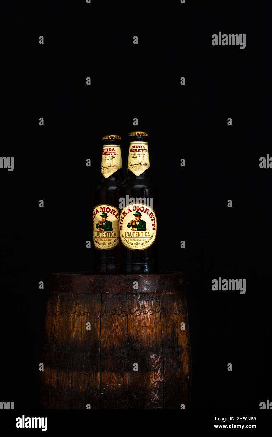 Bottle of Birra Moretti beer on wooden barrel with dark background ...