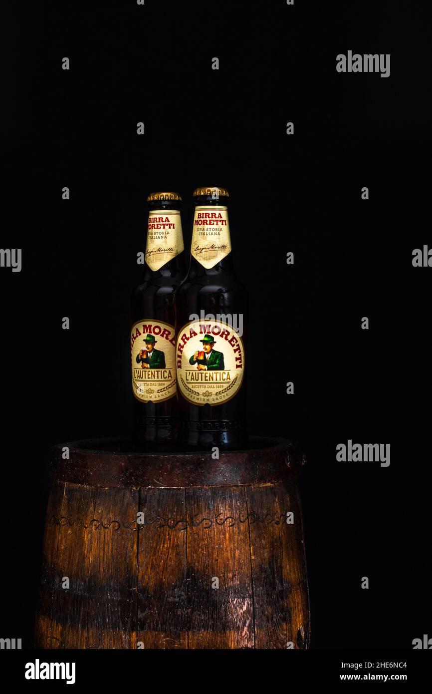 Bottle of Birra Moretti beer on wooden barrel with dark background ...