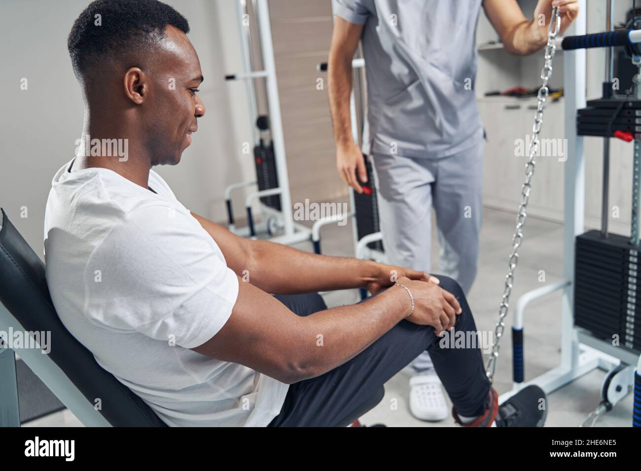 Man doing one-leg raise using exercise machine Stock Photo - Alamy