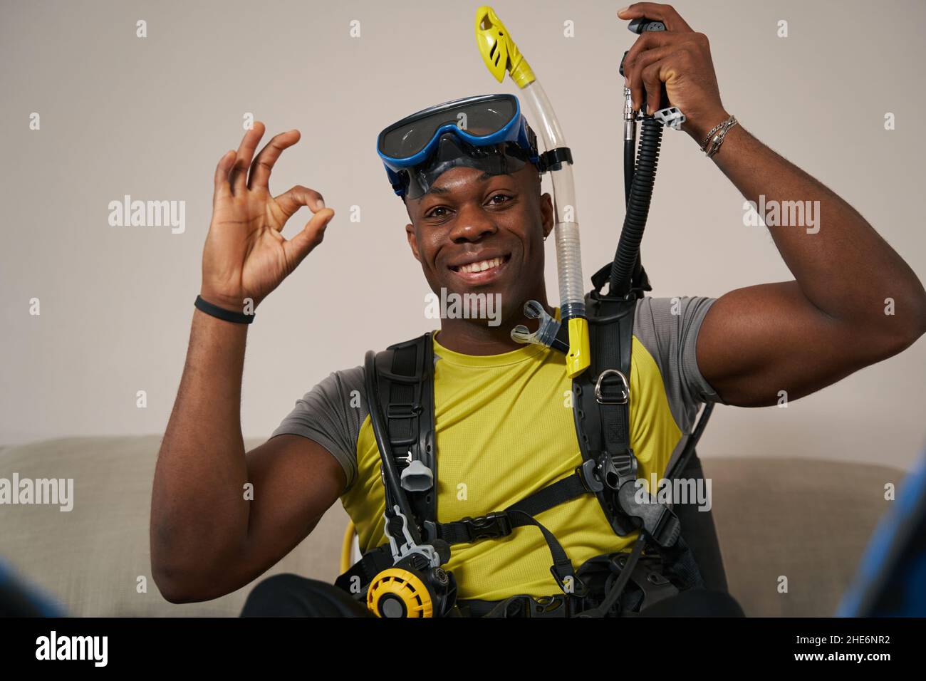 Pleased man showing ok sign while sitting in diving suit Stock Photo ...