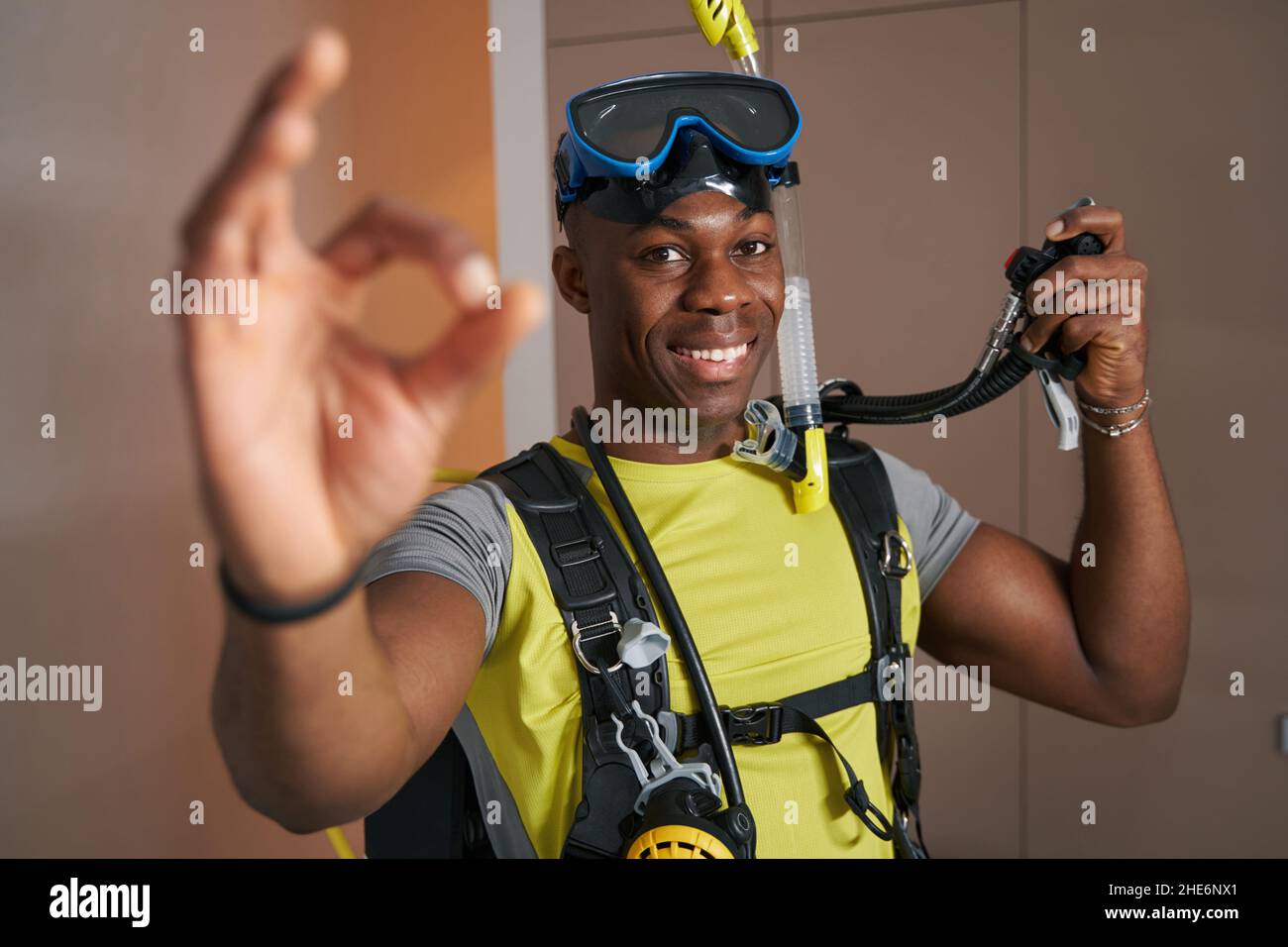 Joyful scuba diver in room showing ok gesture Stock Photo - Alamy