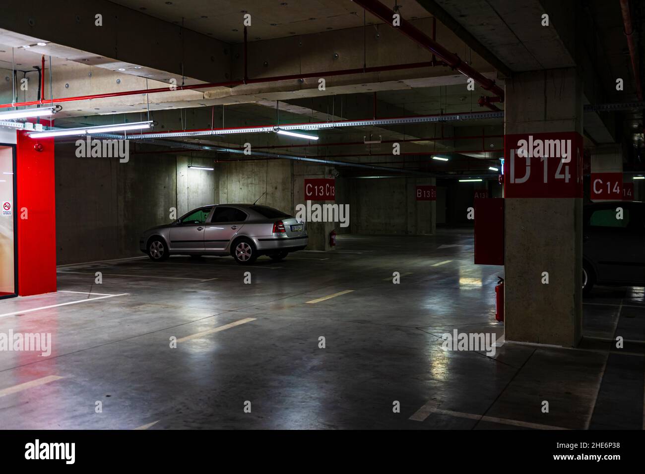 Parking garage interior with a few parked cars. Underground parking garage in Bucharest, Romania ...