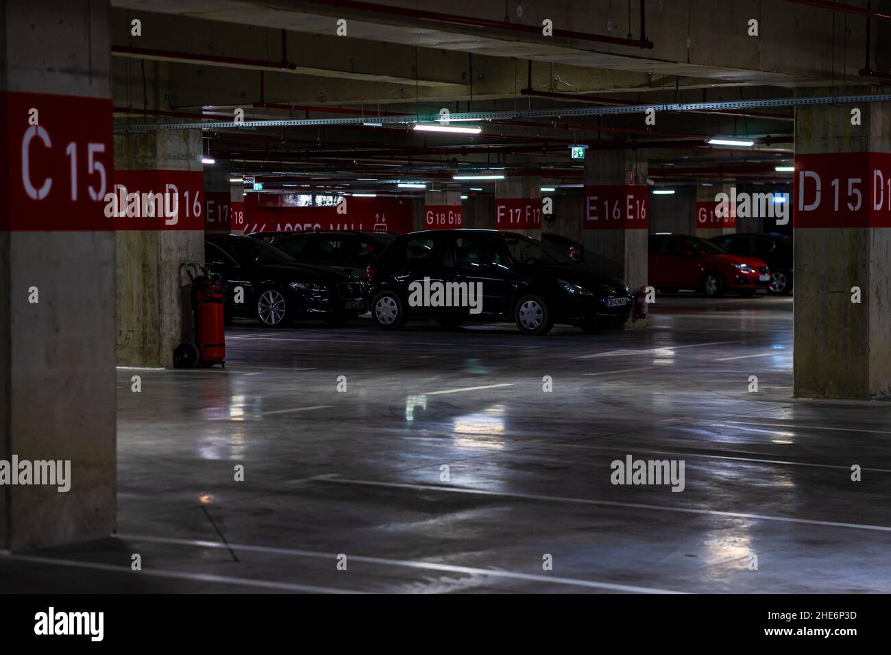 Parking garage interior with a few parked cars. Underground parking ...