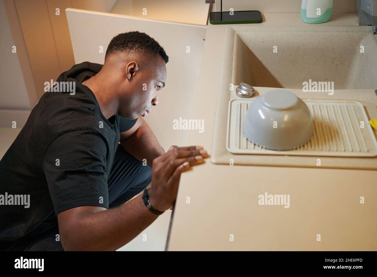 Man looking inside open drawer in the kitchen Stock Photo - Alamy