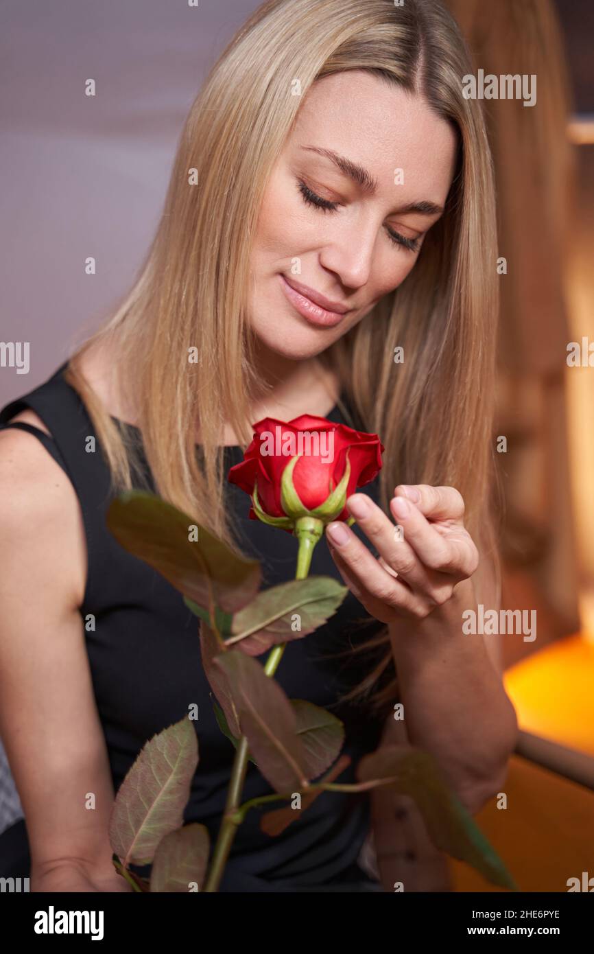 Female sitting with rose flower in restaurant Stock Photo - Alamy