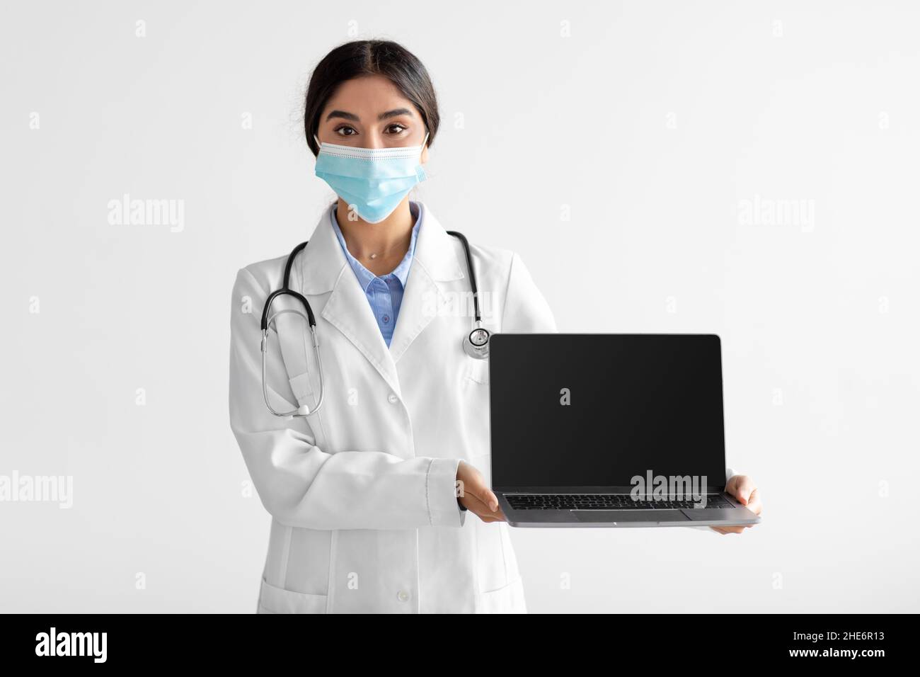 Young attractive hindu woman doctor in uniform and protective mask ...
