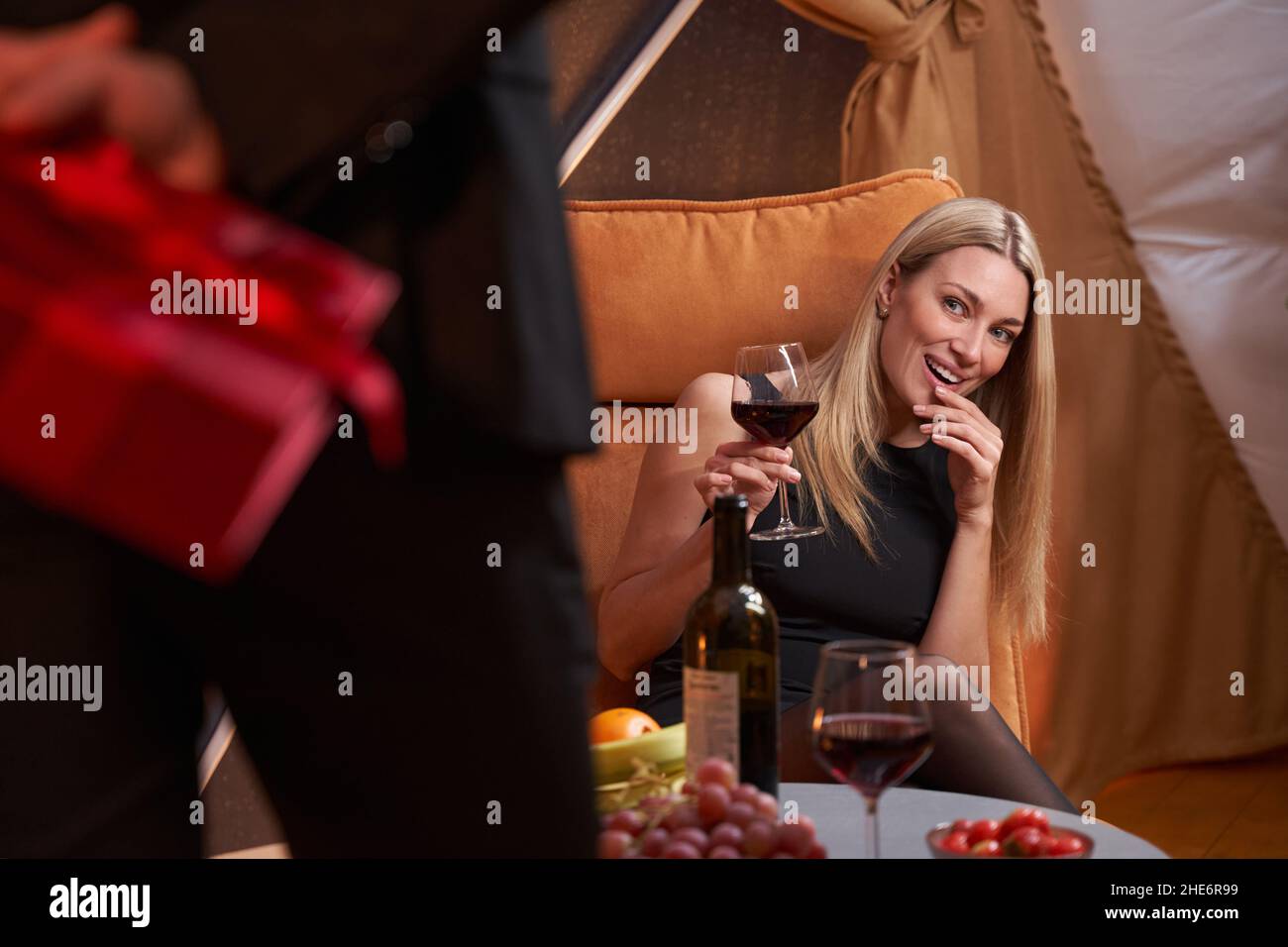Interested woman peeking at present from the table Stock Photo - Alamy