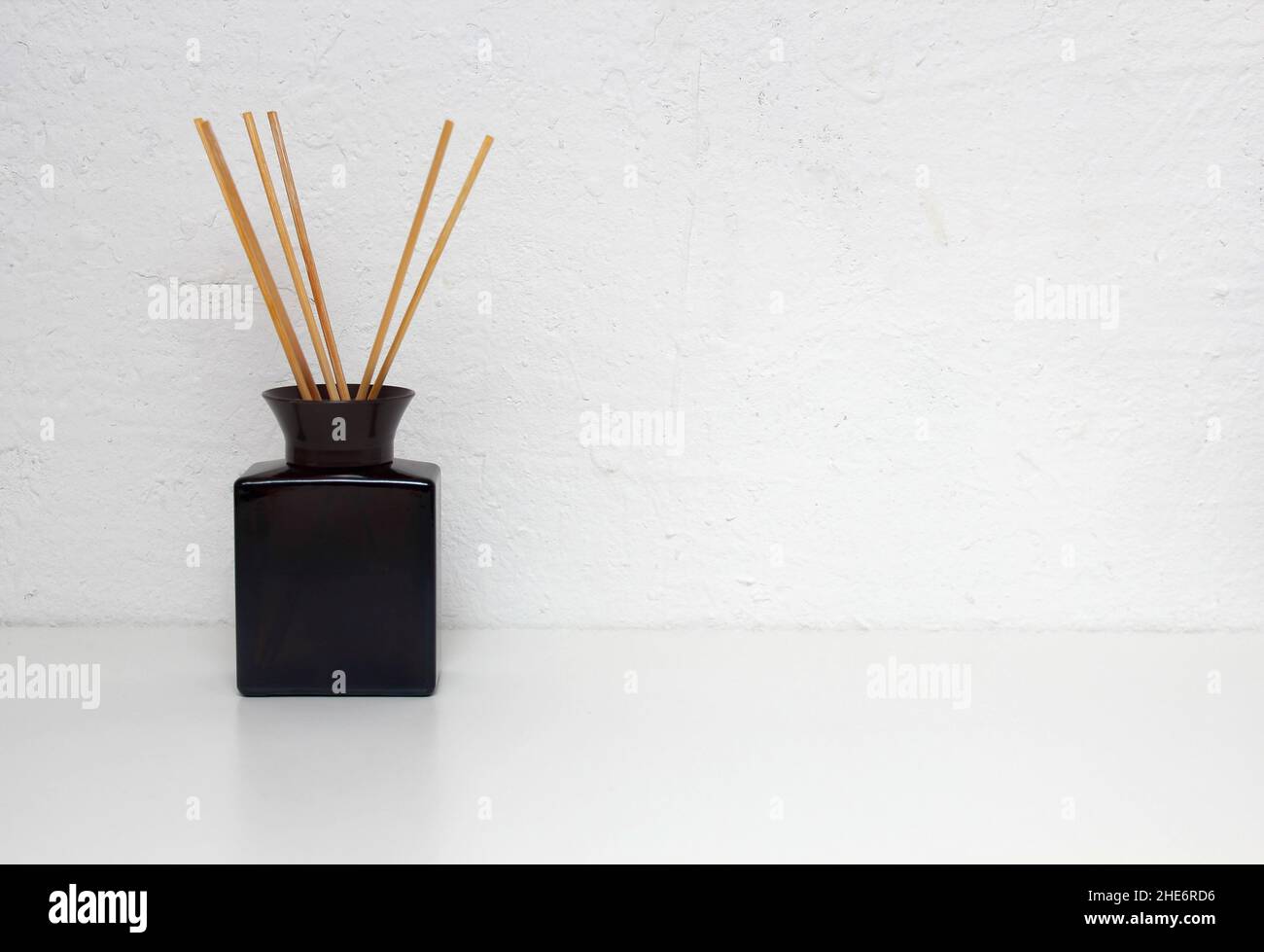 Aroma diffuser with wooden sticks for home on background of white paint ...