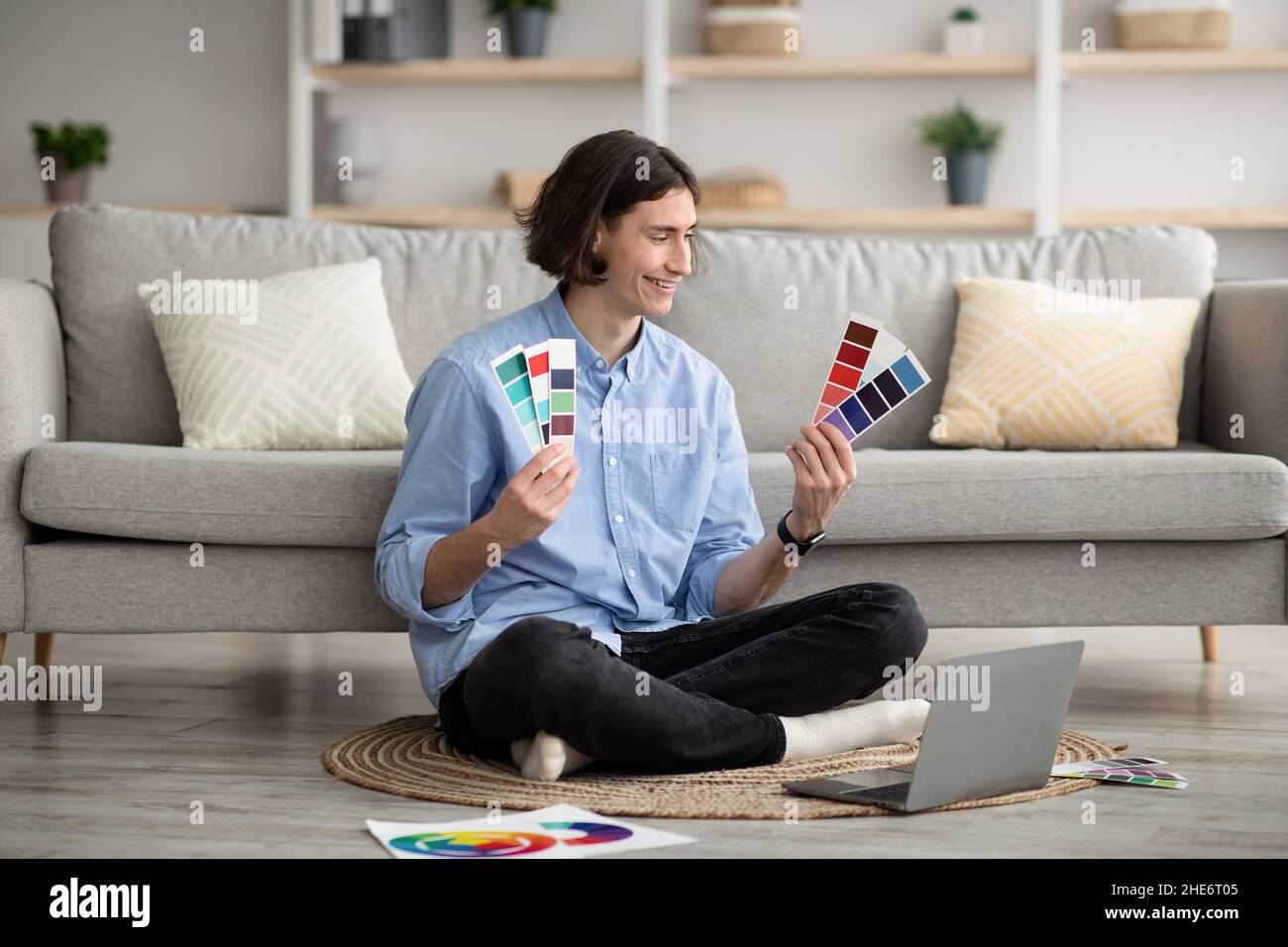 Happy freelance graphic designer guy working with laptop and color ...