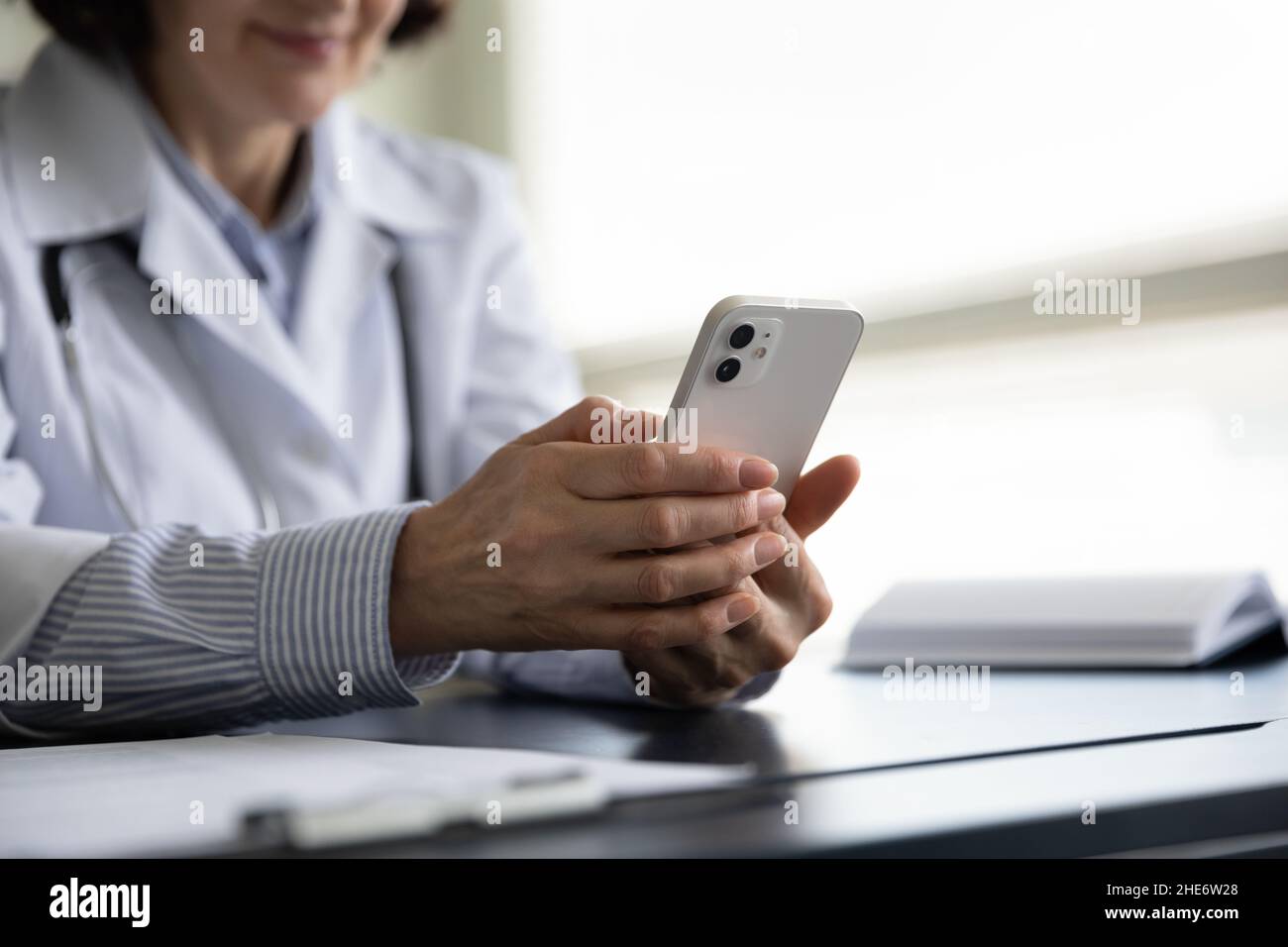 Close up middle aged female doctor using cellphone Stock Photo - Alamy