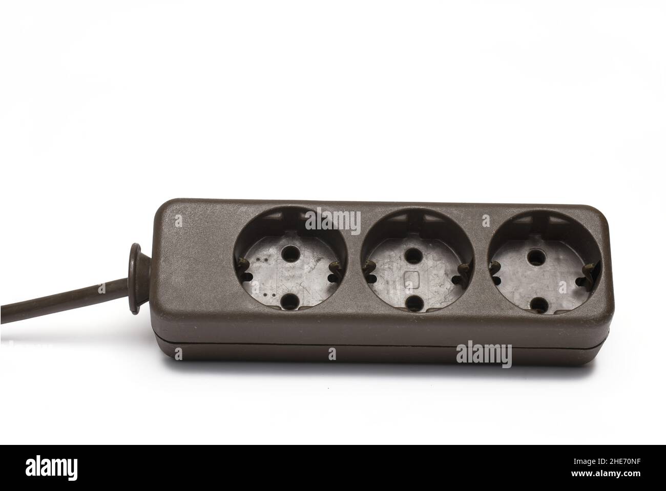 Close up of electric dark brown light current triple plug with three ...