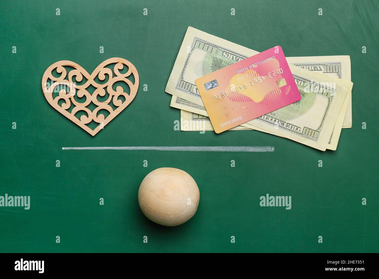 Dollar banknotes with credit card and heart on drawn scales on ...