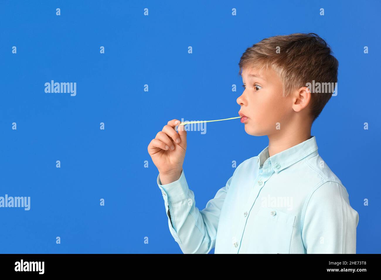 Cute little boy chewing gum on blue background Stock Photo - Alamy