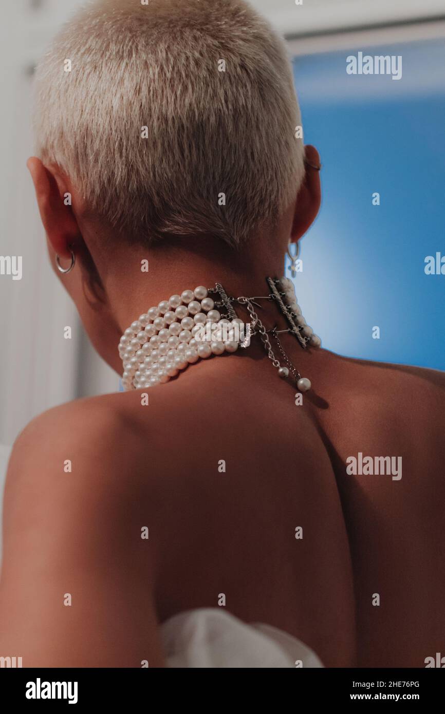 Classic jewelry made of white pearls on a woman's neck. Back view ...