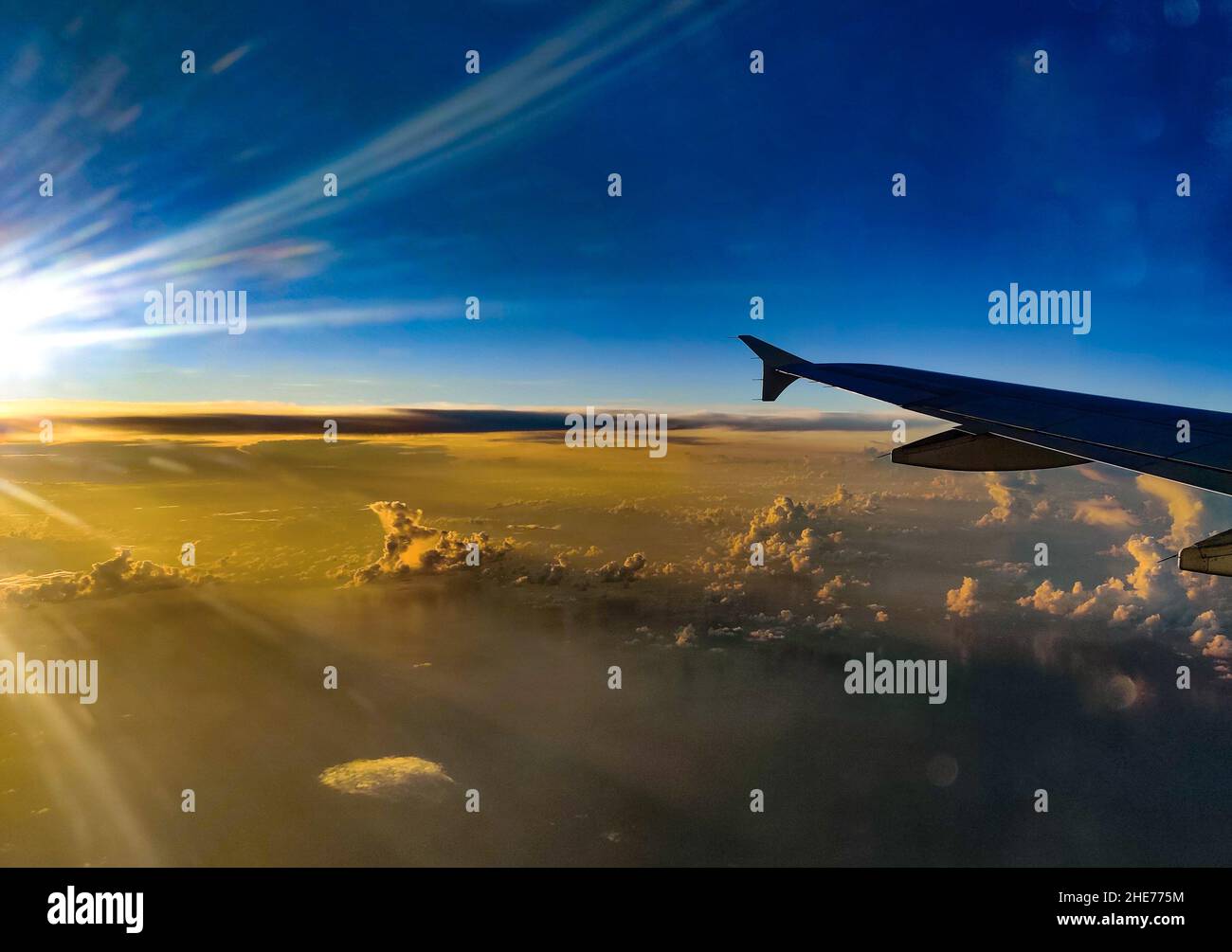 Closeup of a plane wing above the clouds covered in sunlight Stock ...