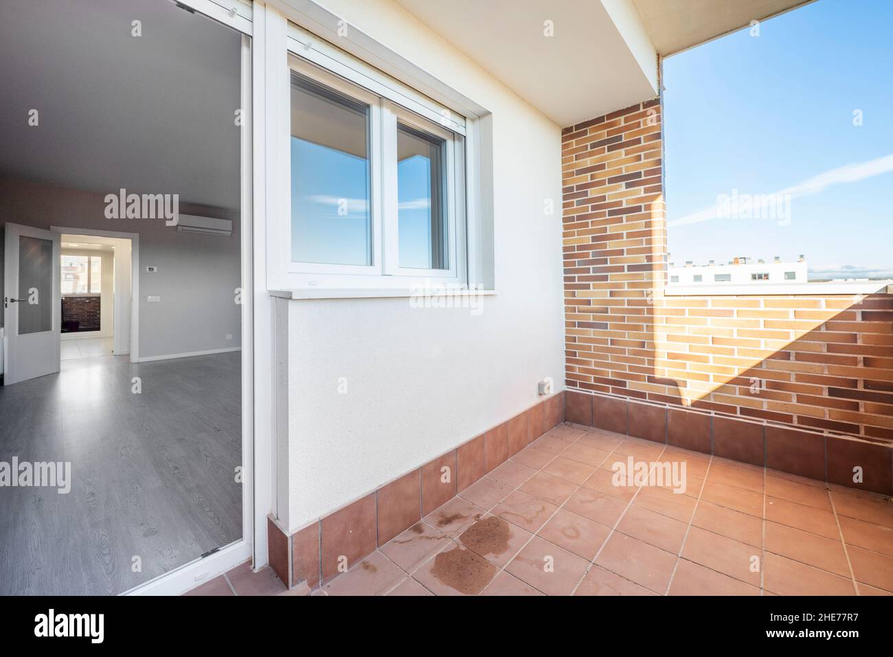 Terrace of an empty apartment with brown exposed brick and living room ...