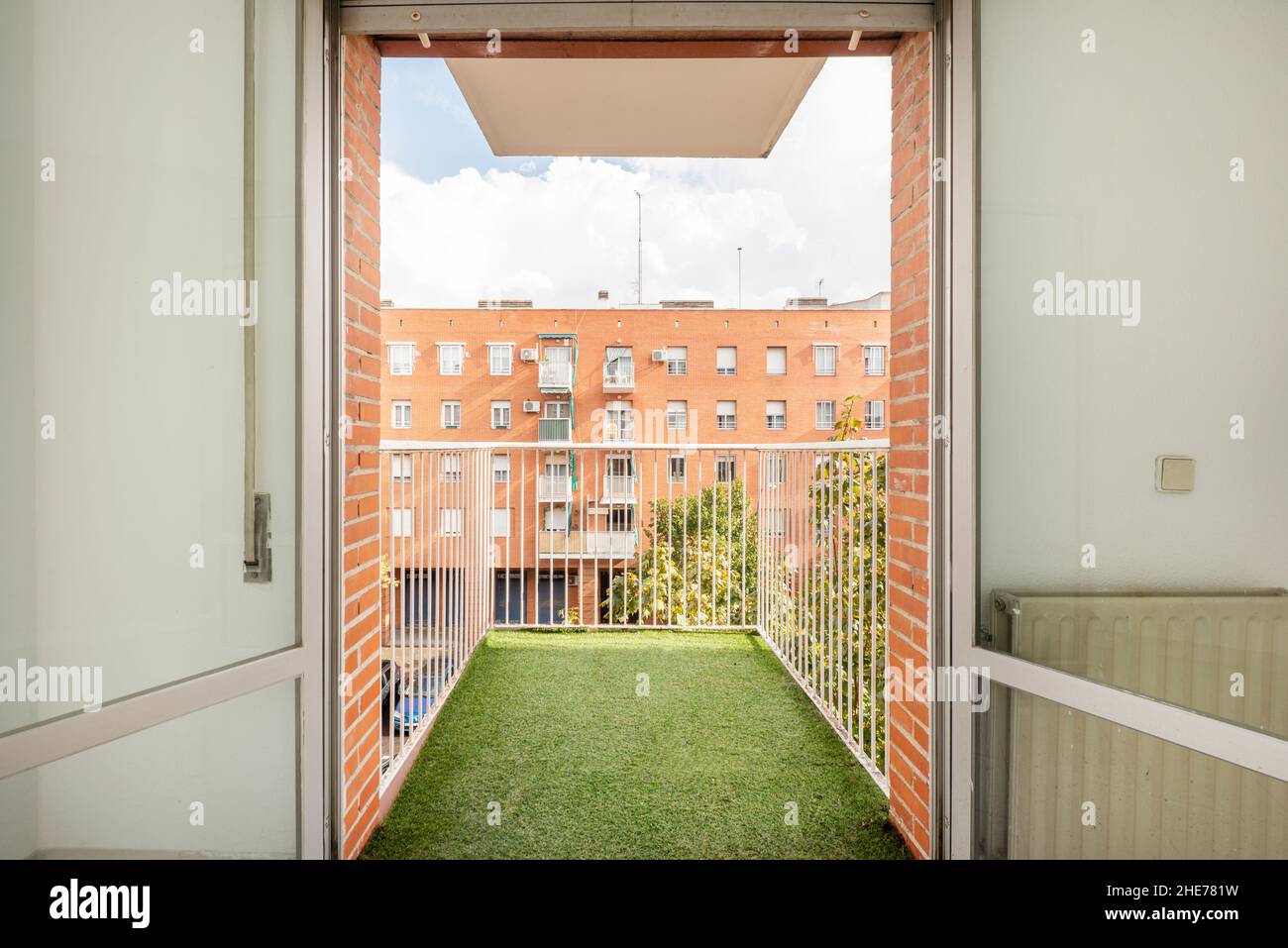 Small terrace with white metal railing and artificial grass floor Stock ...
