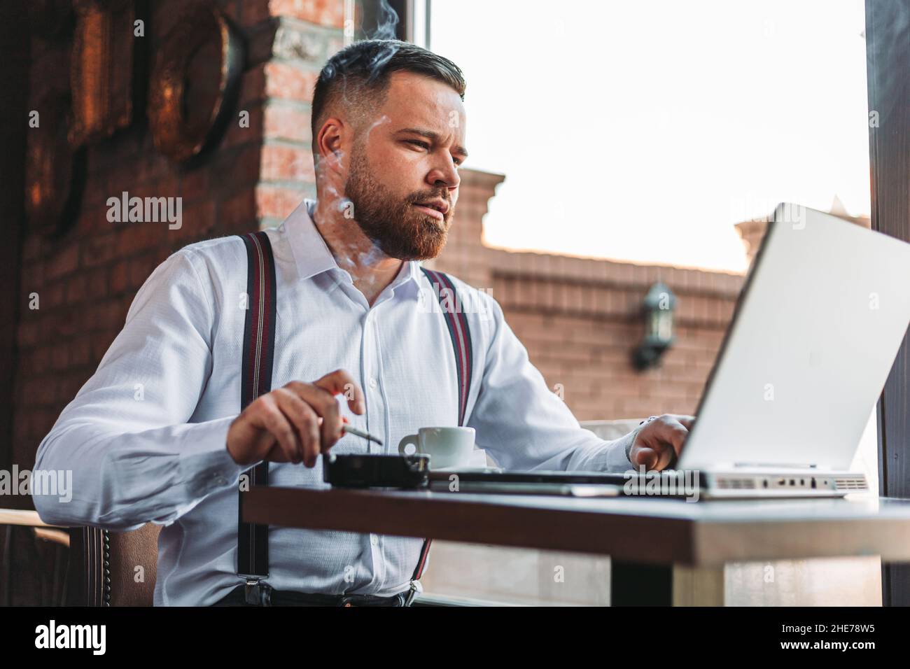Handsome young man sitting smoking hi-res stock photography and images ...